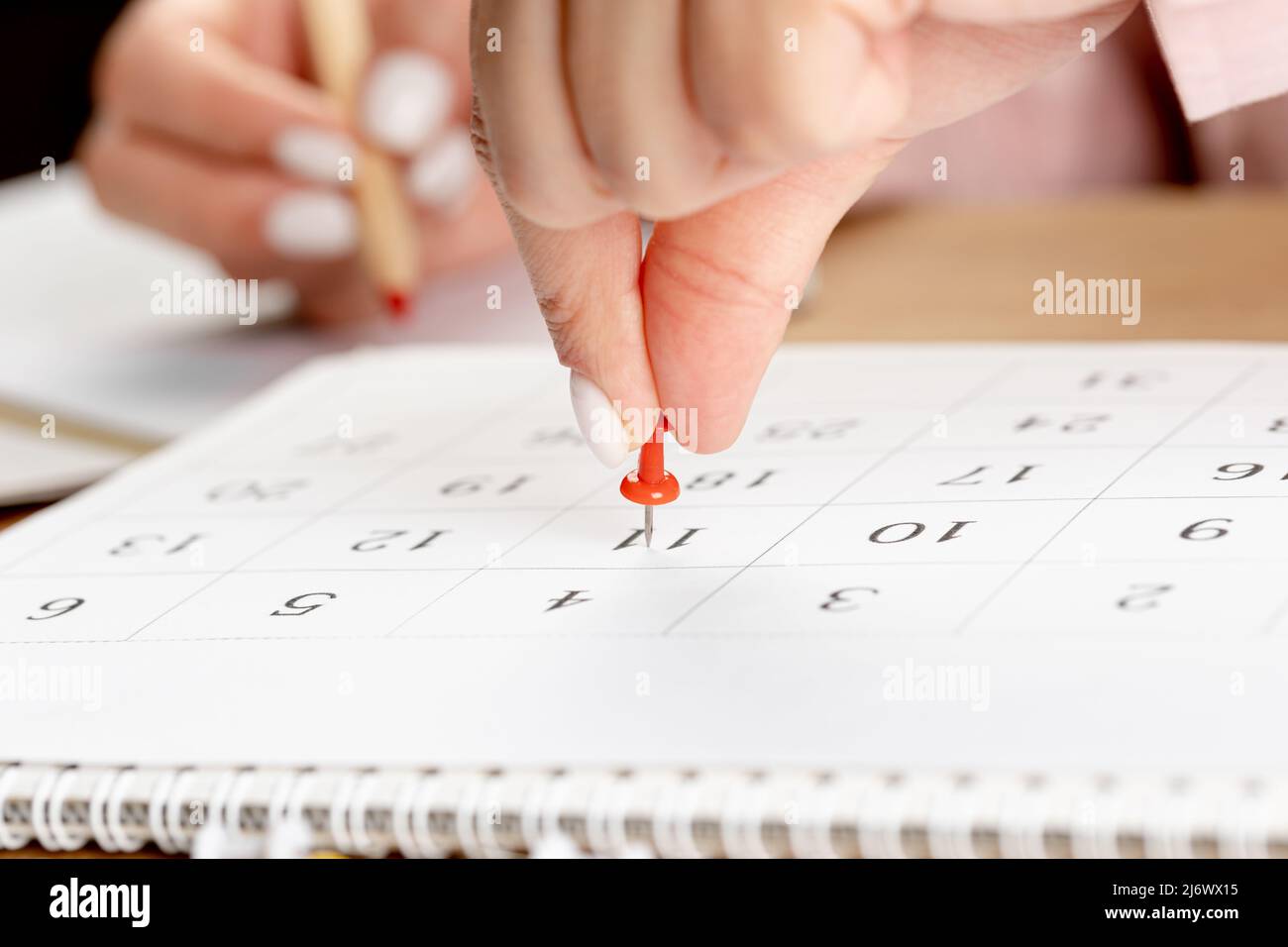 red Hand pin stuck on the day of the month in the calendar, business ...