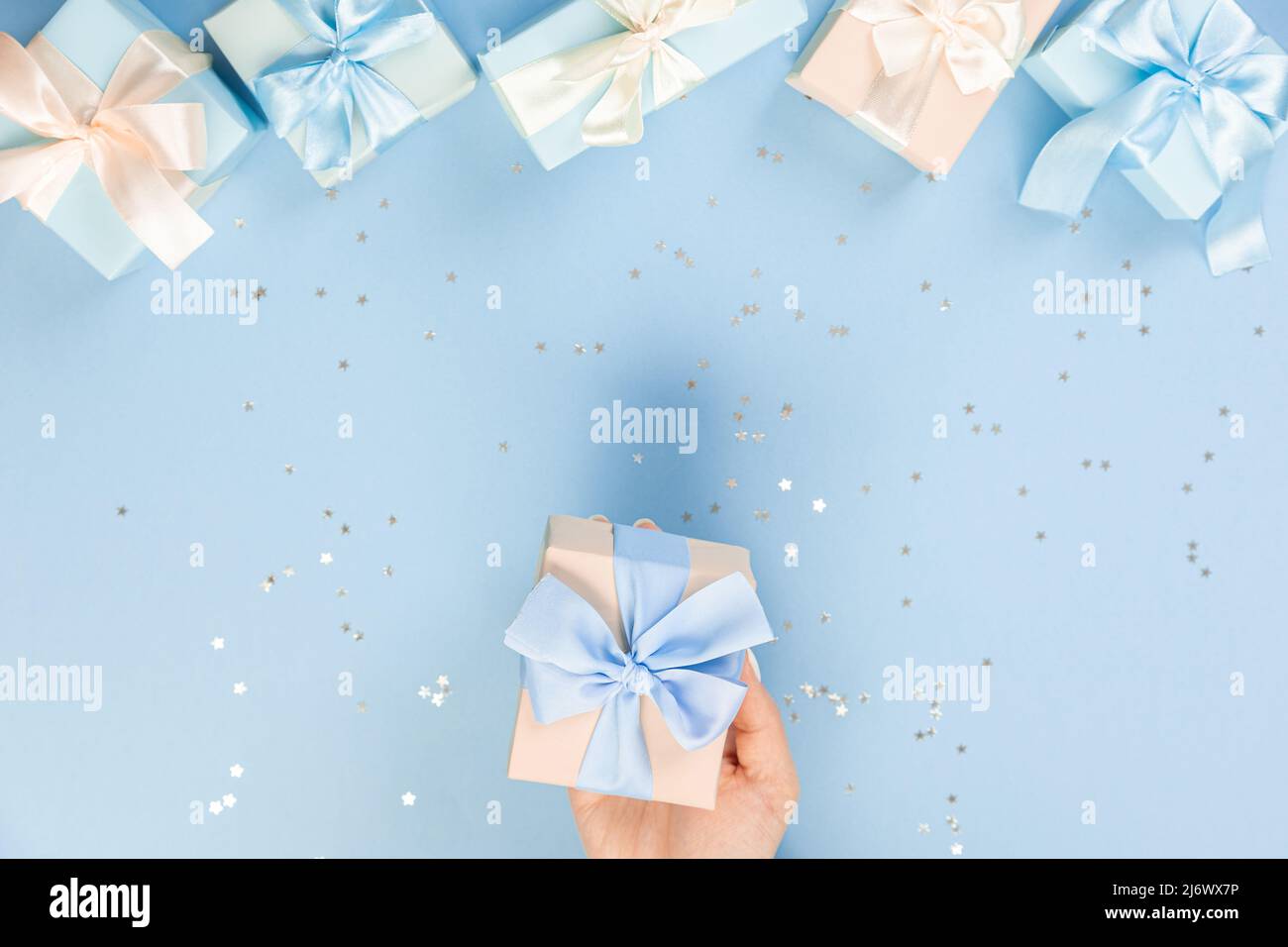 Flat lay of women's hands holding a gift wrapped and decorated with a ...