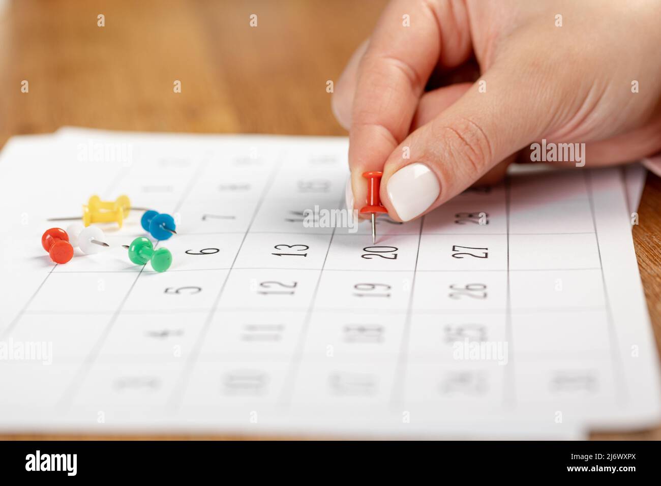 red Hand pin stuck on the day of the month in the calendar, business ...