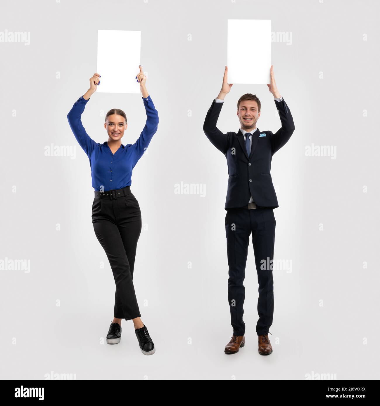 Happy people holding blank white advertising billboard at studio ...