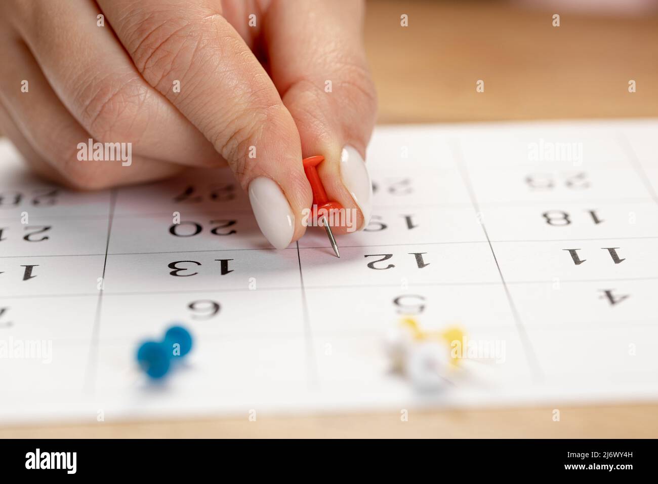 red Hand pin stuck on the day of the month in the calendar, business ...