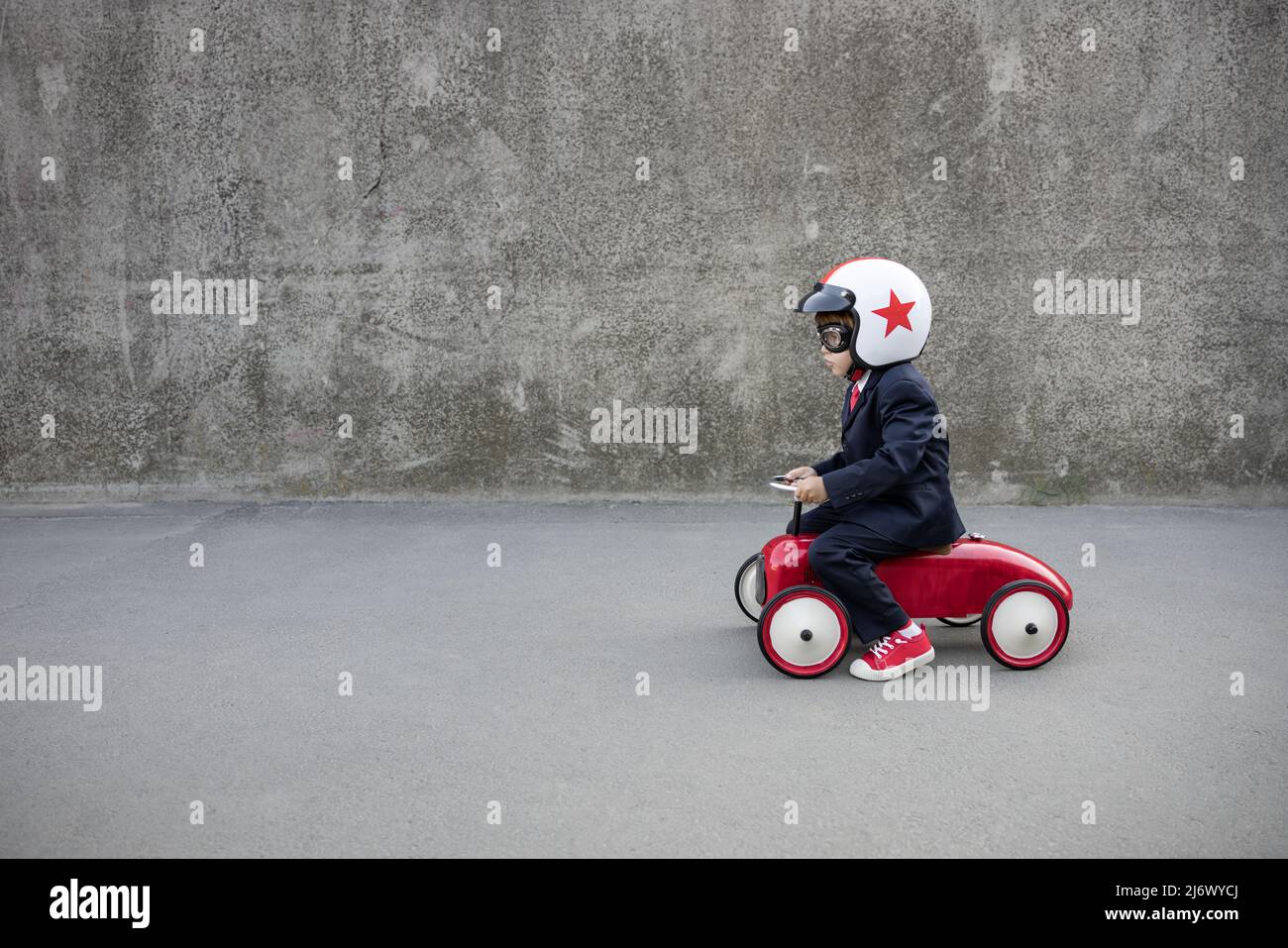 Happy kid pretend to be businessman. Funny child driving retro kids car ...