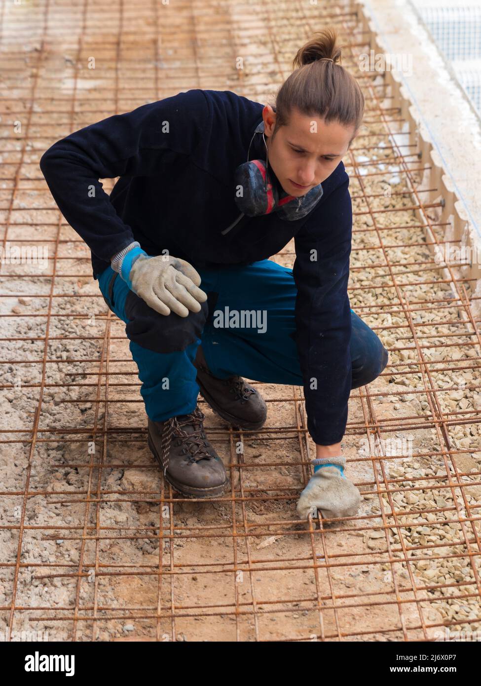 Working man putting grid for reinforcing concrete on the floor in ...