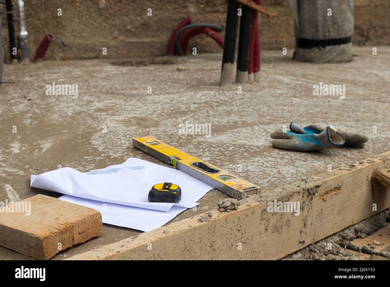 Construction objects and tools perched in concrete floor on ...