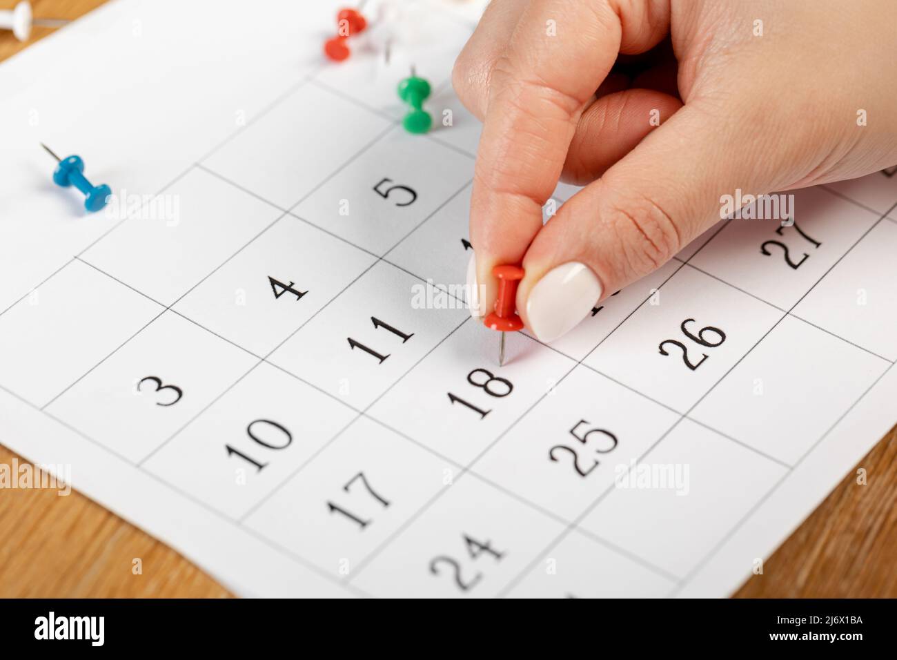 red Hand pin stuck on the day of the month in the calendar, business ...