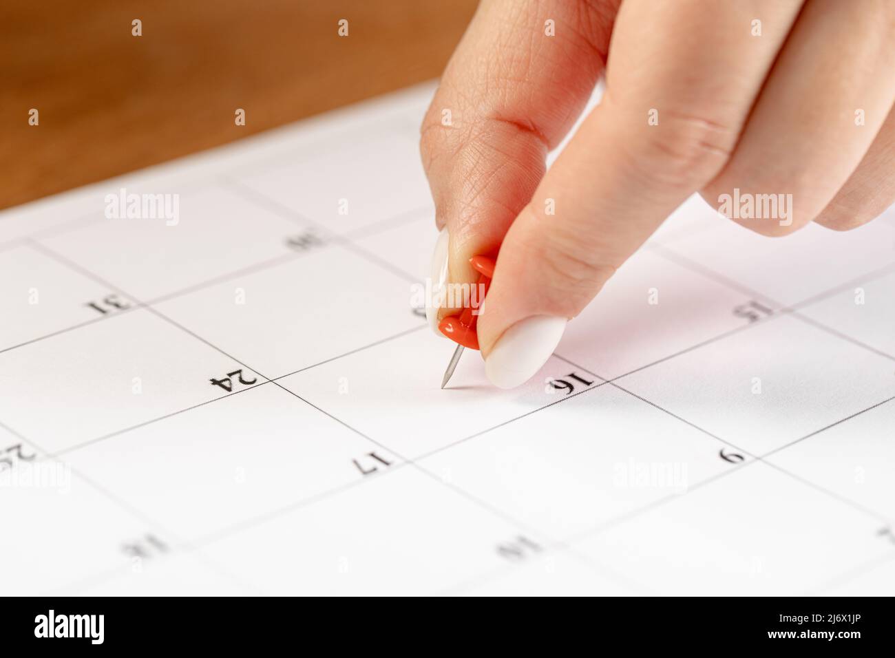 red Hand pin stuck on the day of the month in the calendar, business ...