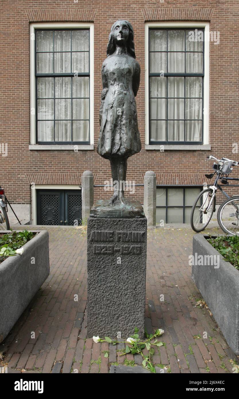 Flowers laid at the Anne Frank (1929-1945) statue near Anne Frank house ...
