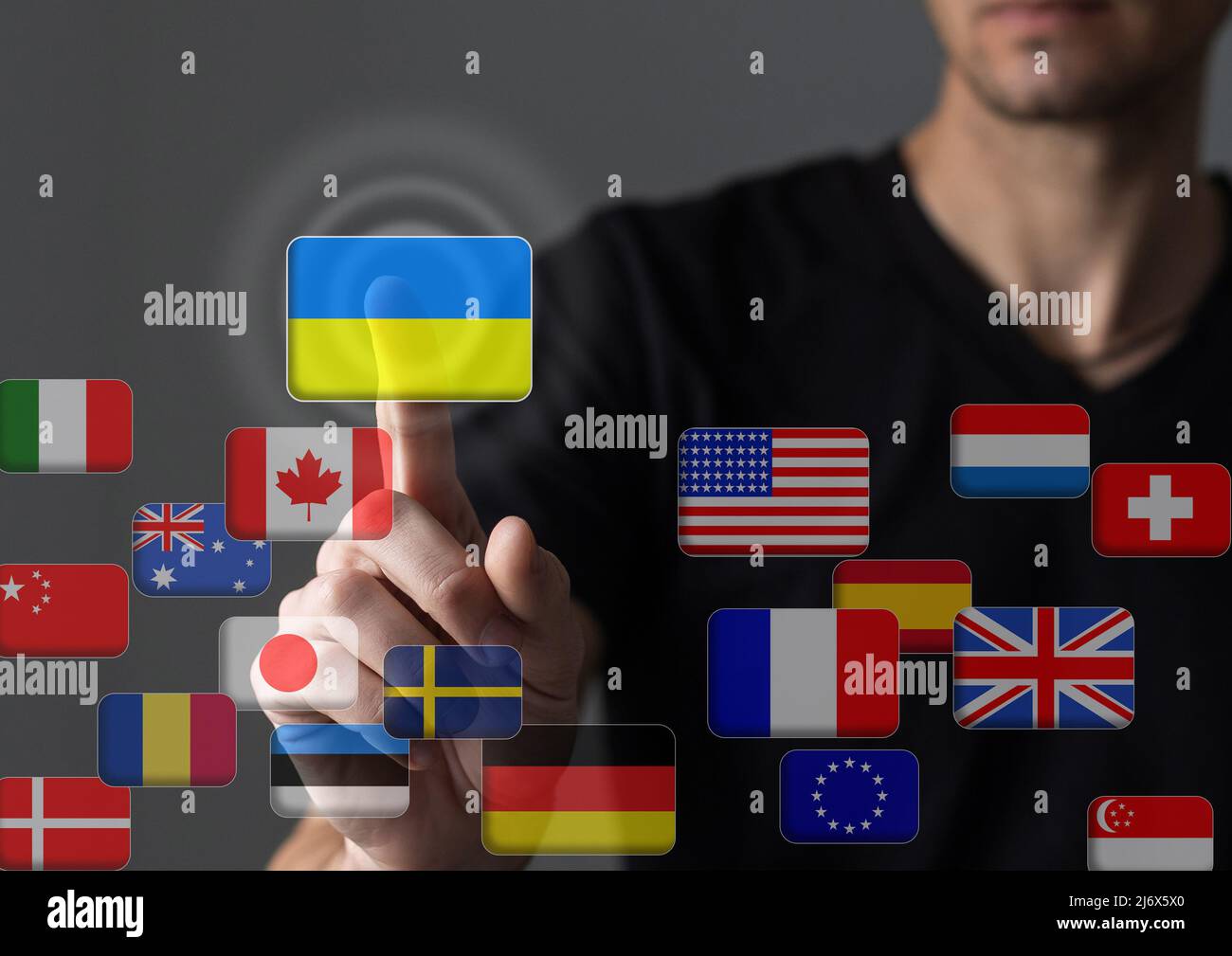 Hand pushing on a touch screen interface, choosing Ukraine. flags of ...