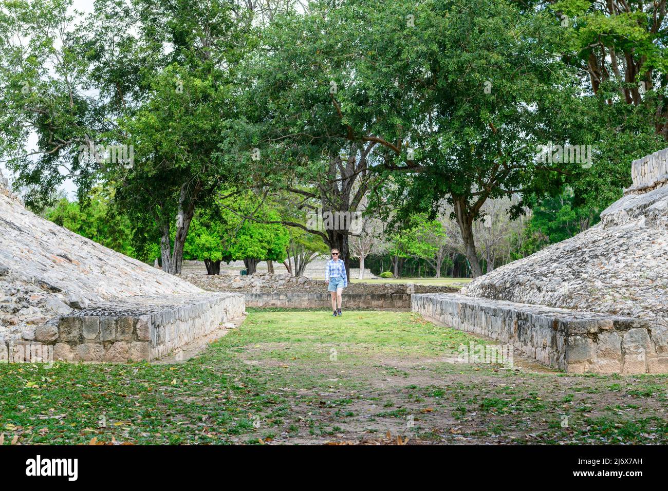 A tourist woman exploring the ruins of Ball Court of ancient mayan city Edzna - famous ...