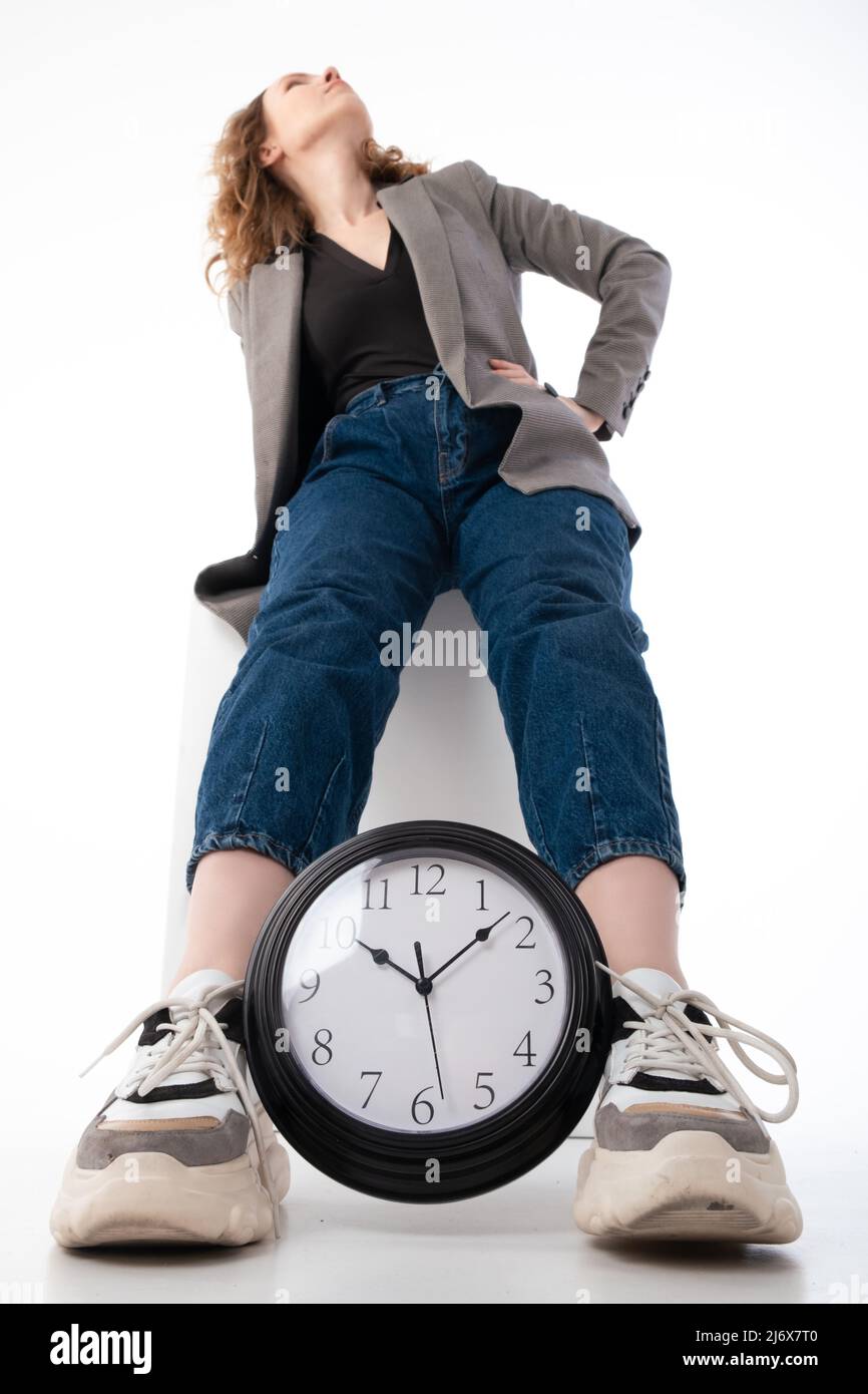 Deadline concept, time management. A woman holds between her legs a ...