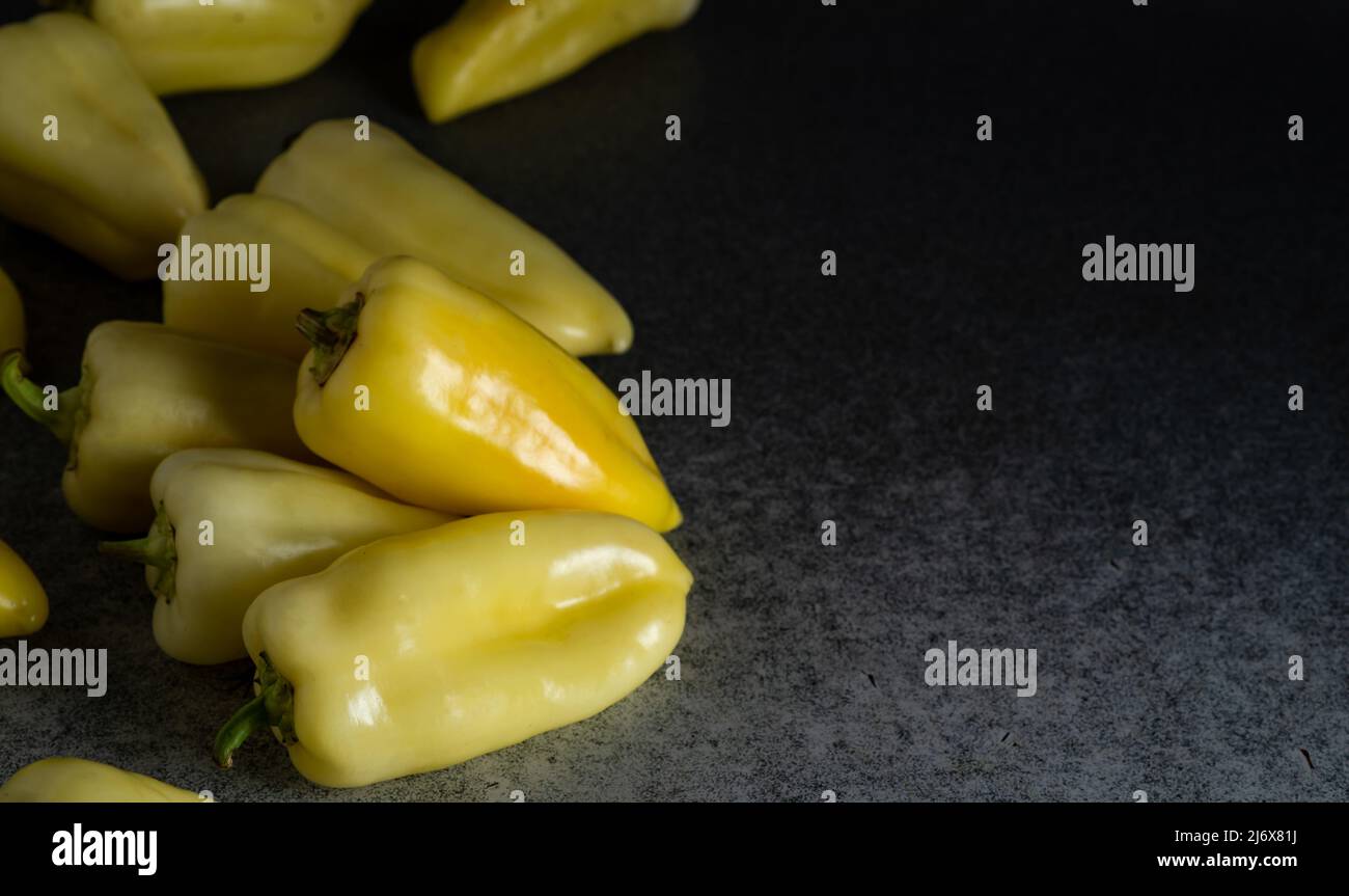 Fresh yellow peppers heap on the kitchen table. Preparation for cooking ...