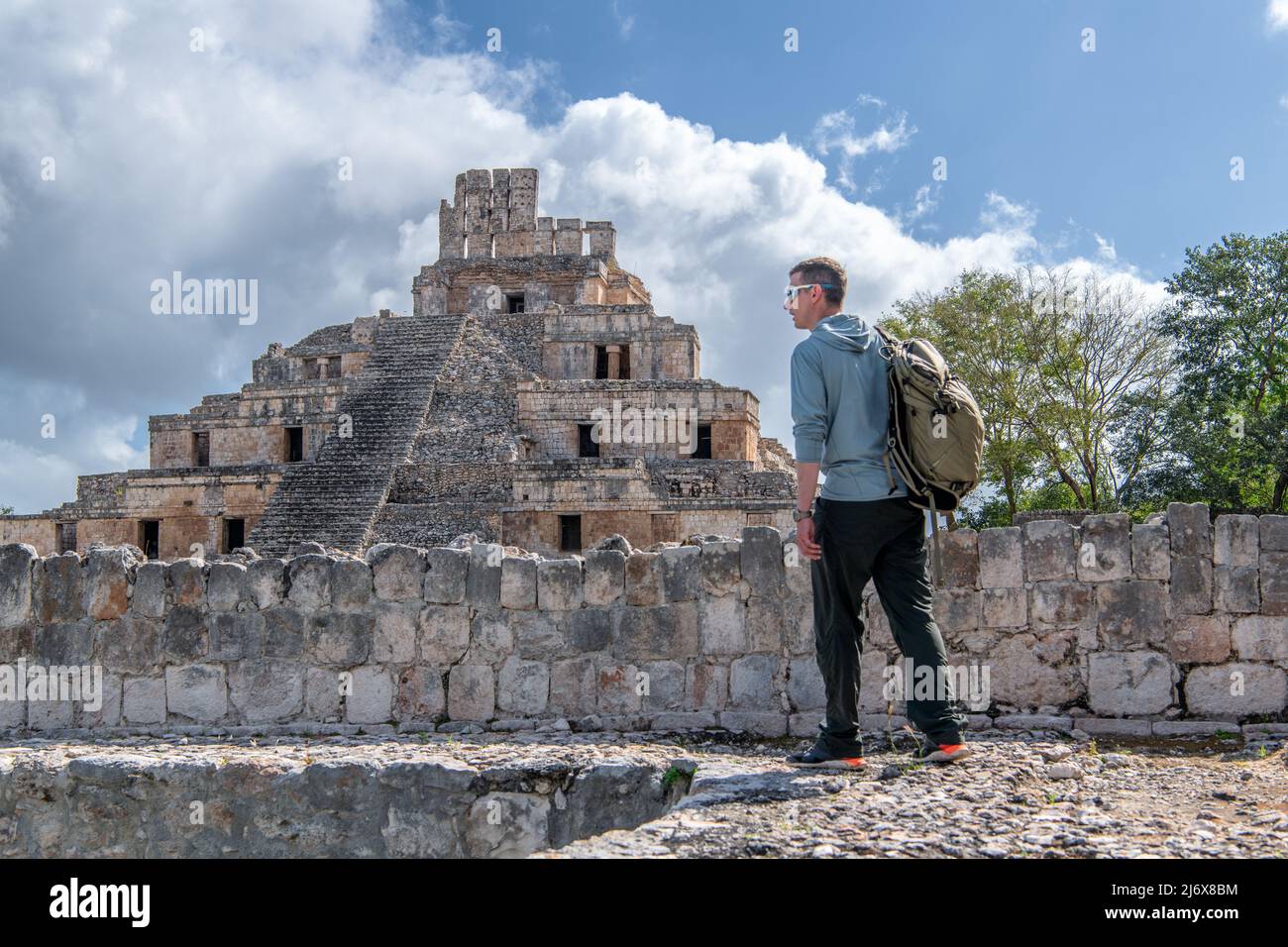 Tourist caucasian man with a backpack exploring mayan ruins of Temple ...