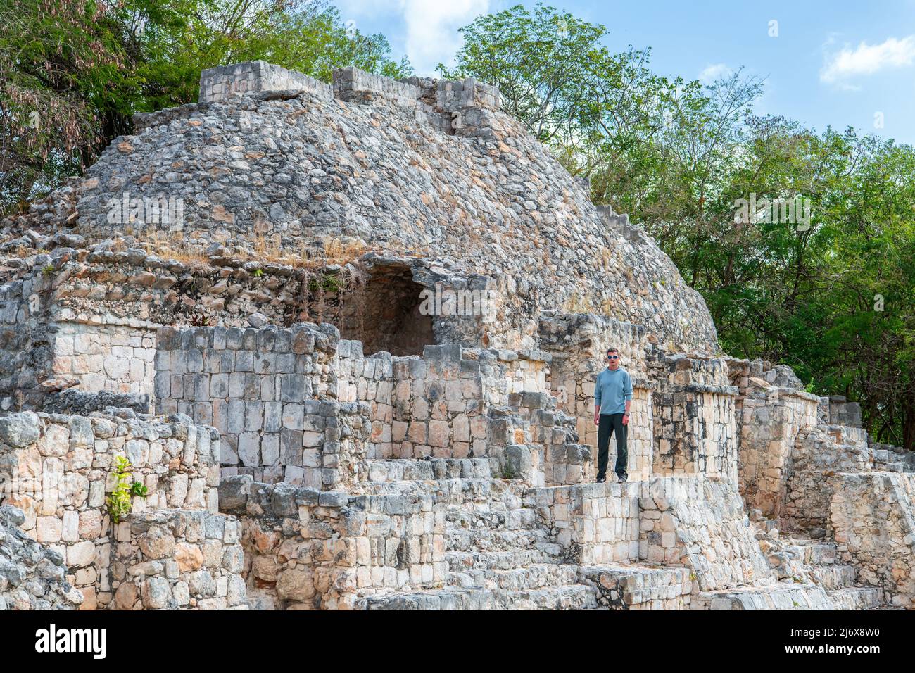 Tourist man posing in front of the ruins of north temple in ancient ...