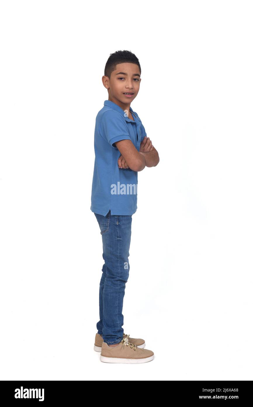 side view of boy arms crossed and looking at camera on white background ...