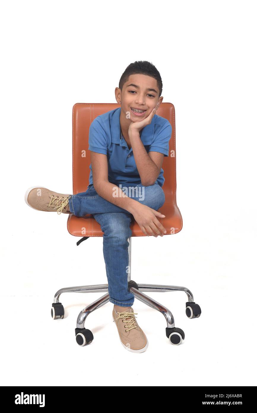front view of a boy who is sitting on a chair looking at camera and ...