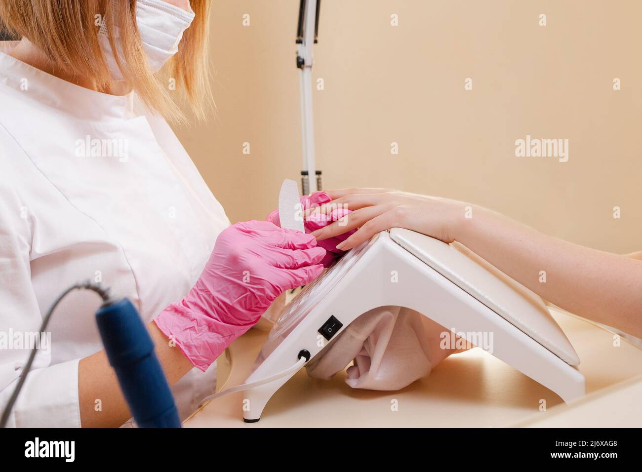 Medicine, cosmetology and manicure. A woman manicure master, in a mask ...