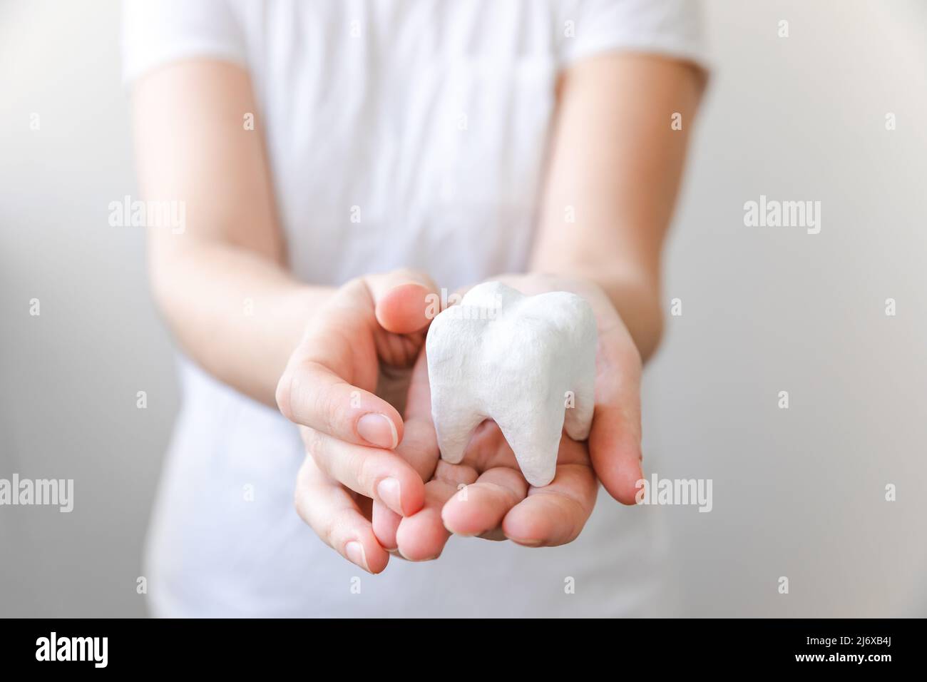 Health dental care concept. Woman hand holding white healthy tooth ...