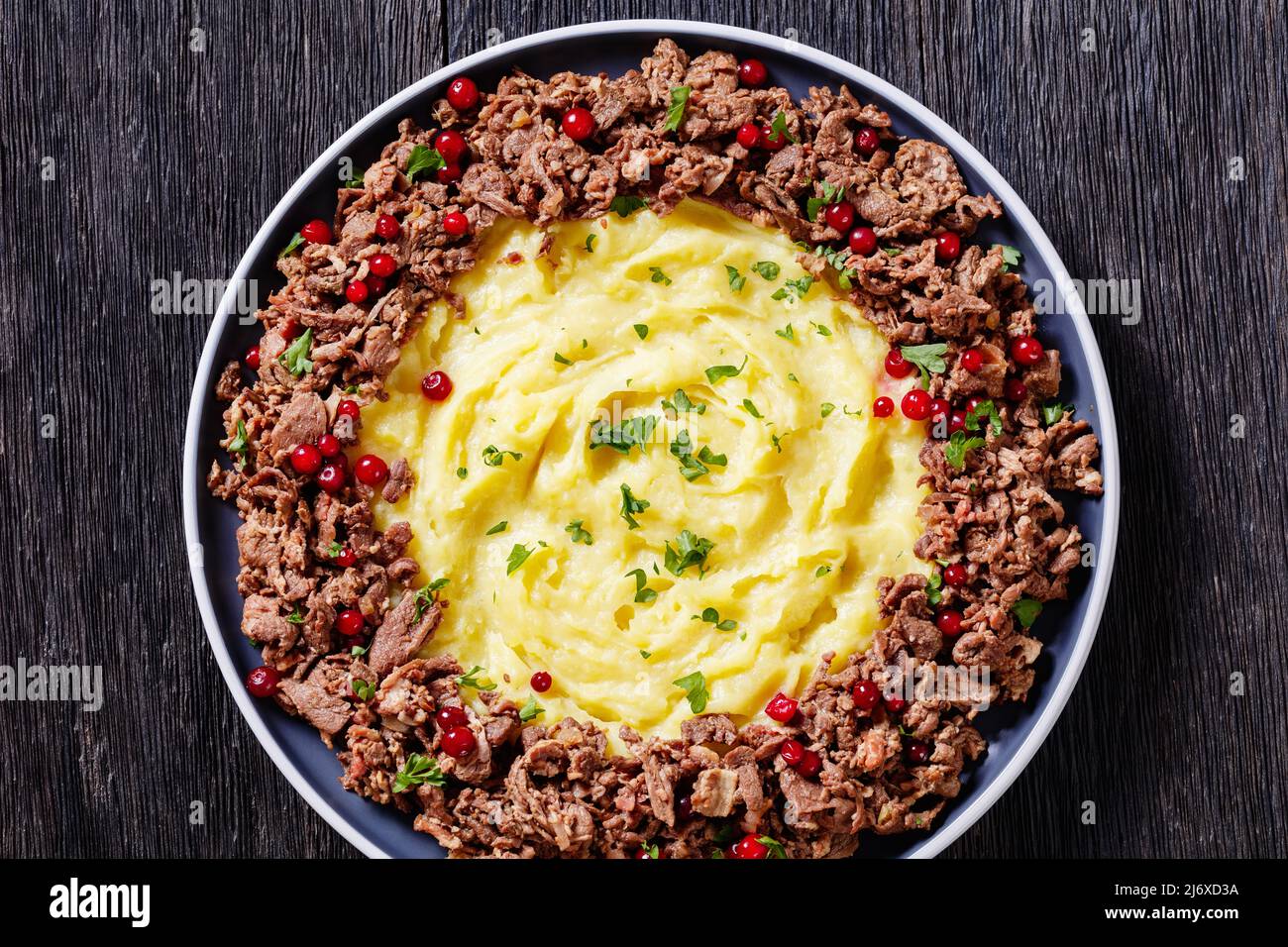 Reindeer Stew with Lingonberries and potato puree on plate on wood ...