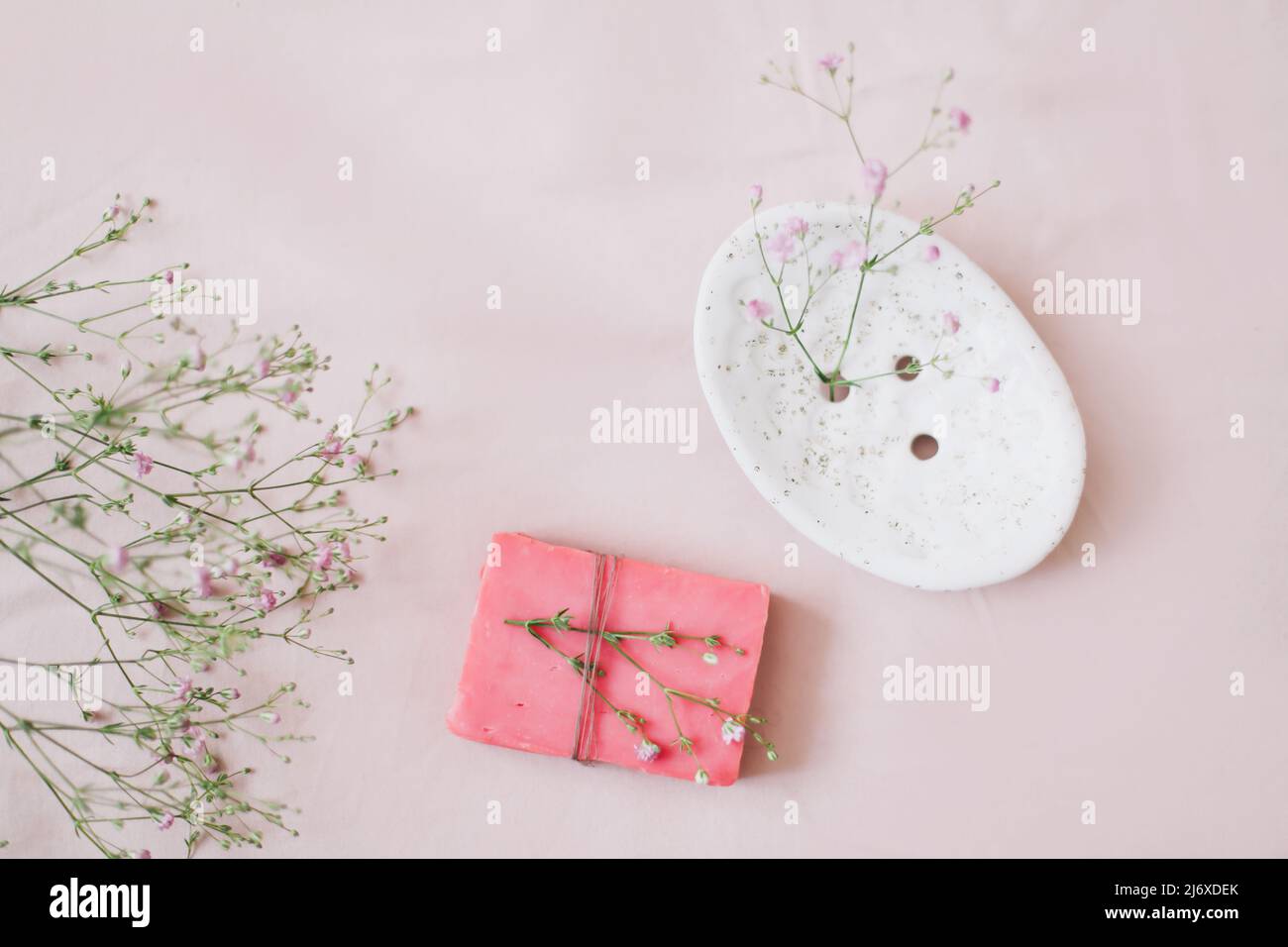 Natural handmade pink soap bar with ceramic soap dish and flowers, spa ...