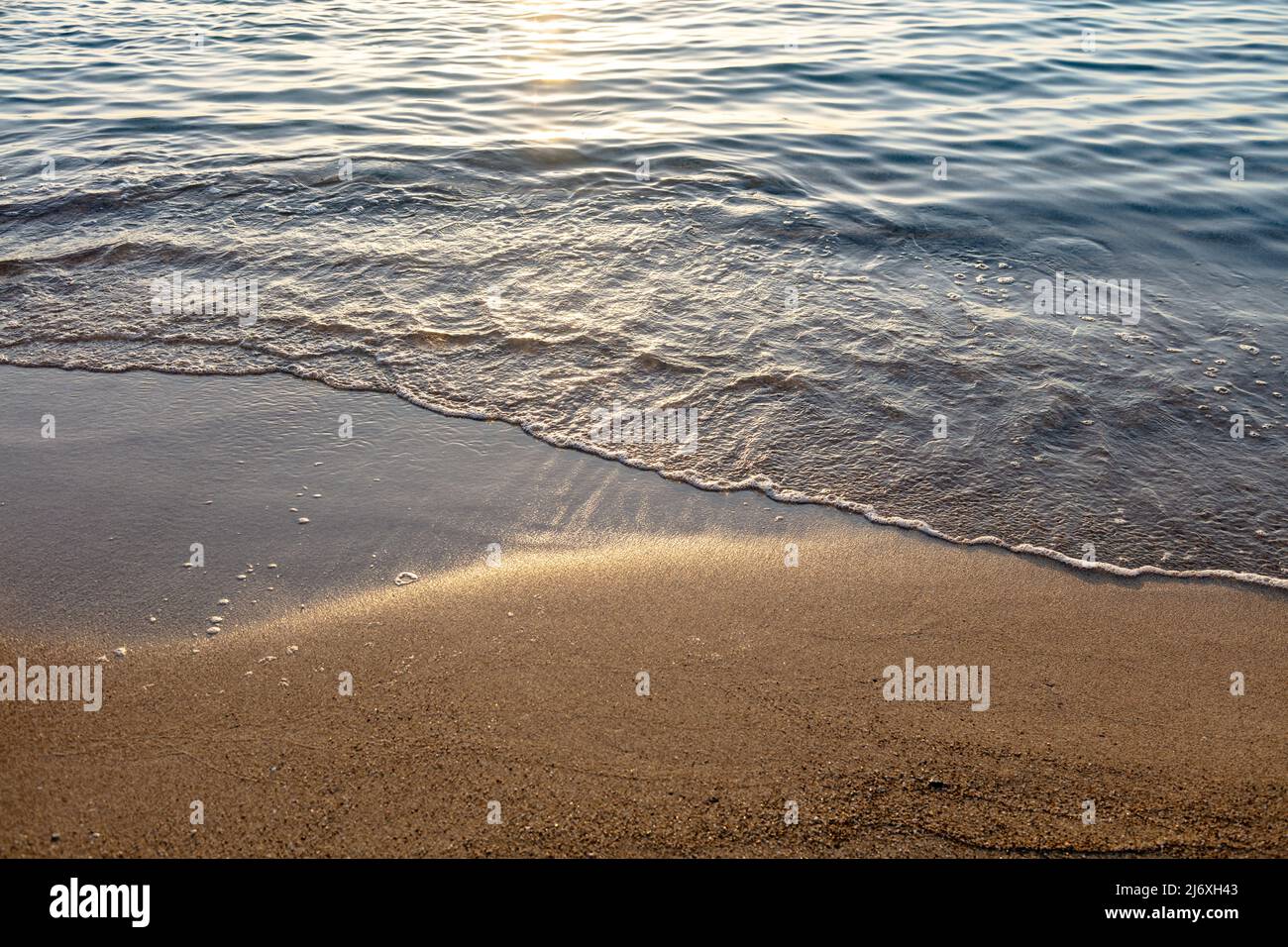 Empty sandy beach at sunset, Greece, close up view. Sea water touch wet ...