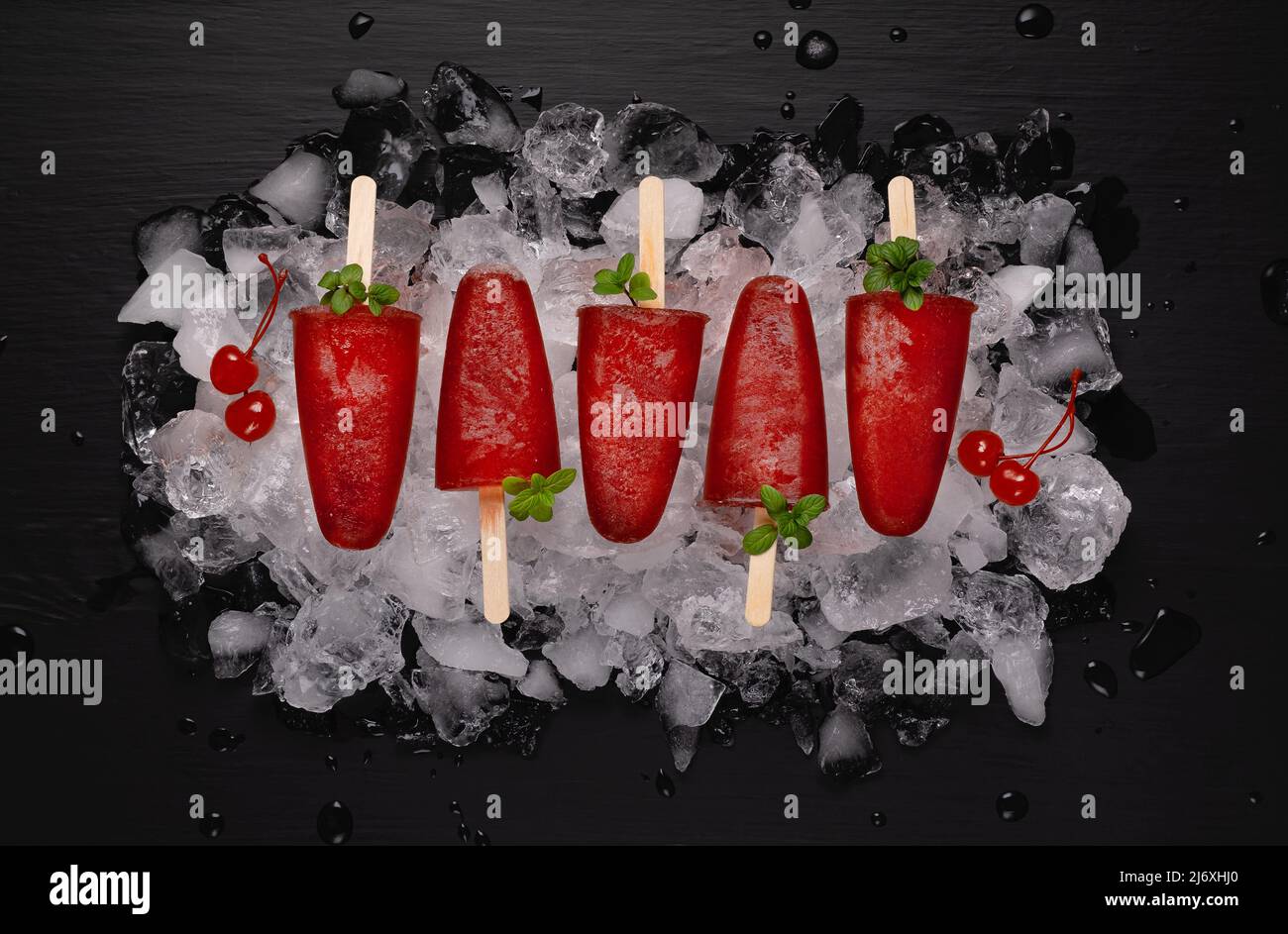 Fruit cherry ice lolly on a black background Stock Photo - Alamy