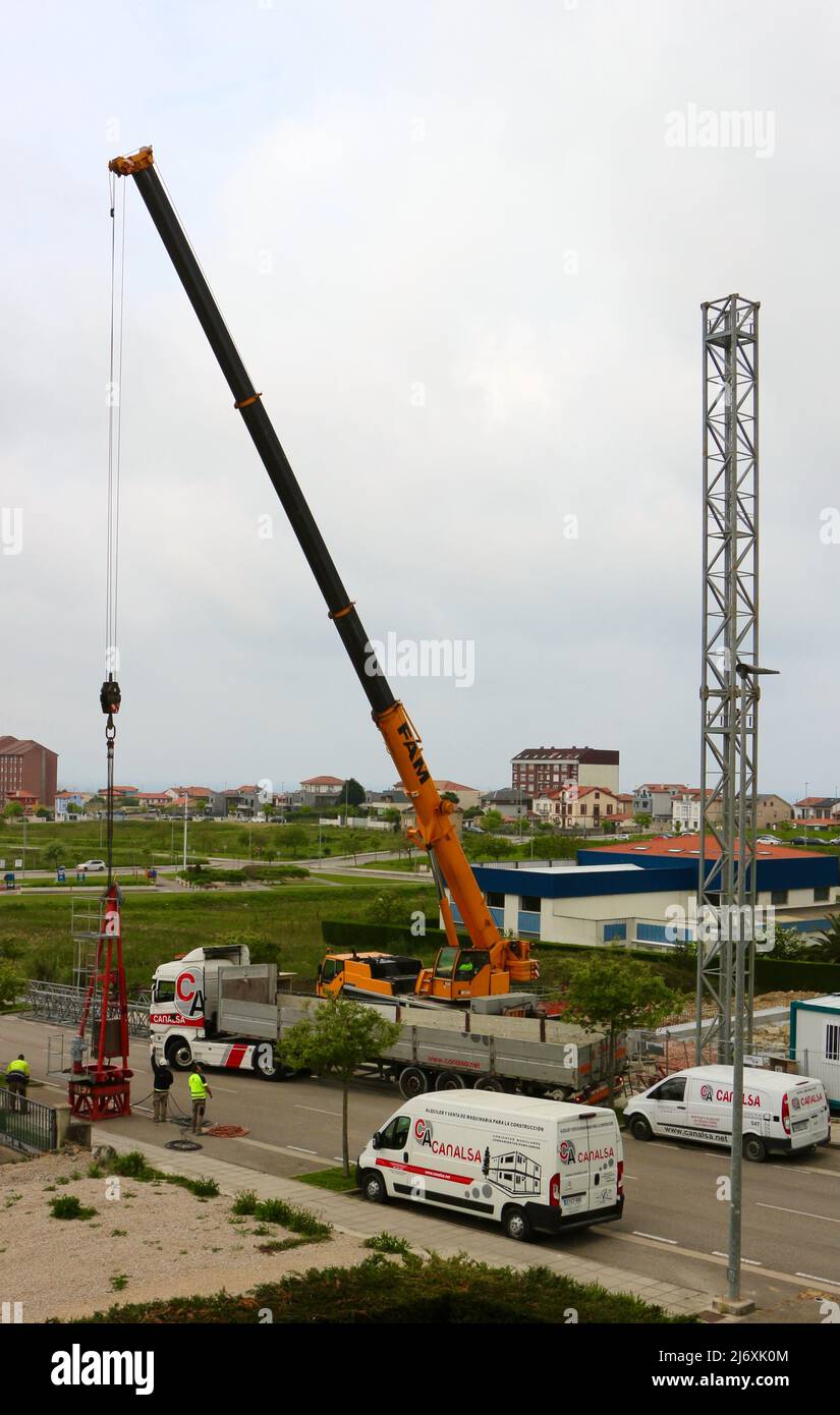 A mobile crane lifting the slewing unit into position on the mast of a ...