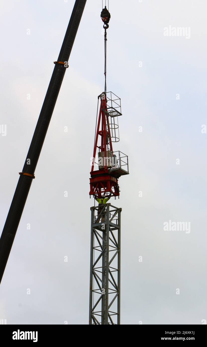 A mobile crane lifting the slewing unit with a construction worker ...