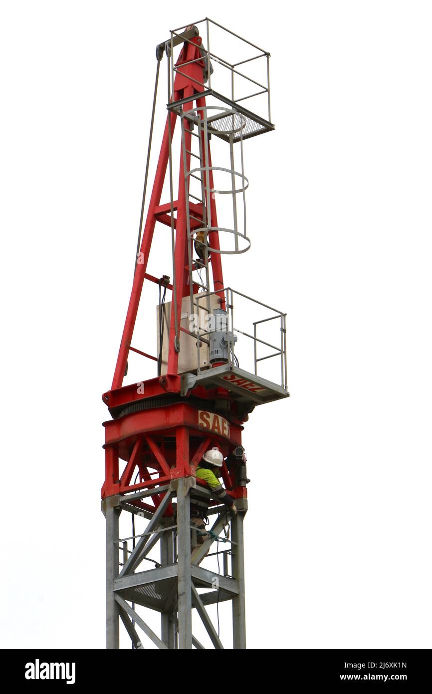 A construction worker fixing the slewing unit onto the mast of a tower ...