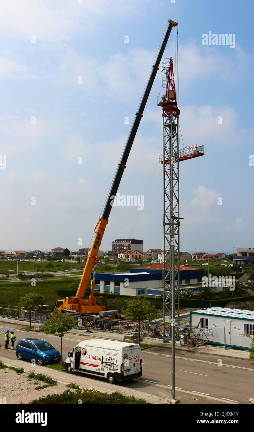 A mobile crane lifting the slewing unit into position on the mast of a ...