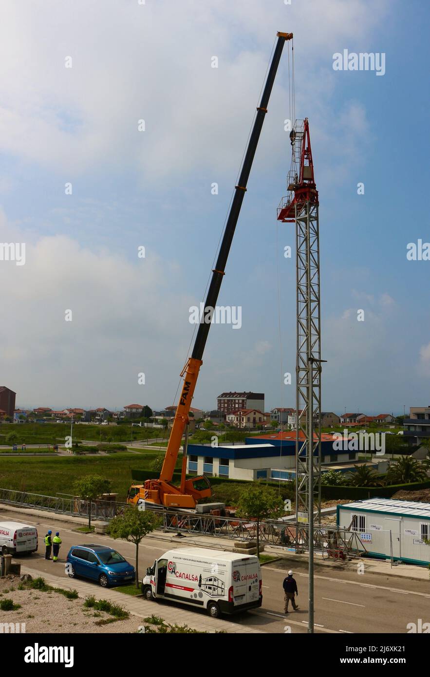 A mobile crane lifting the slewing unit into position on the mast of a ...