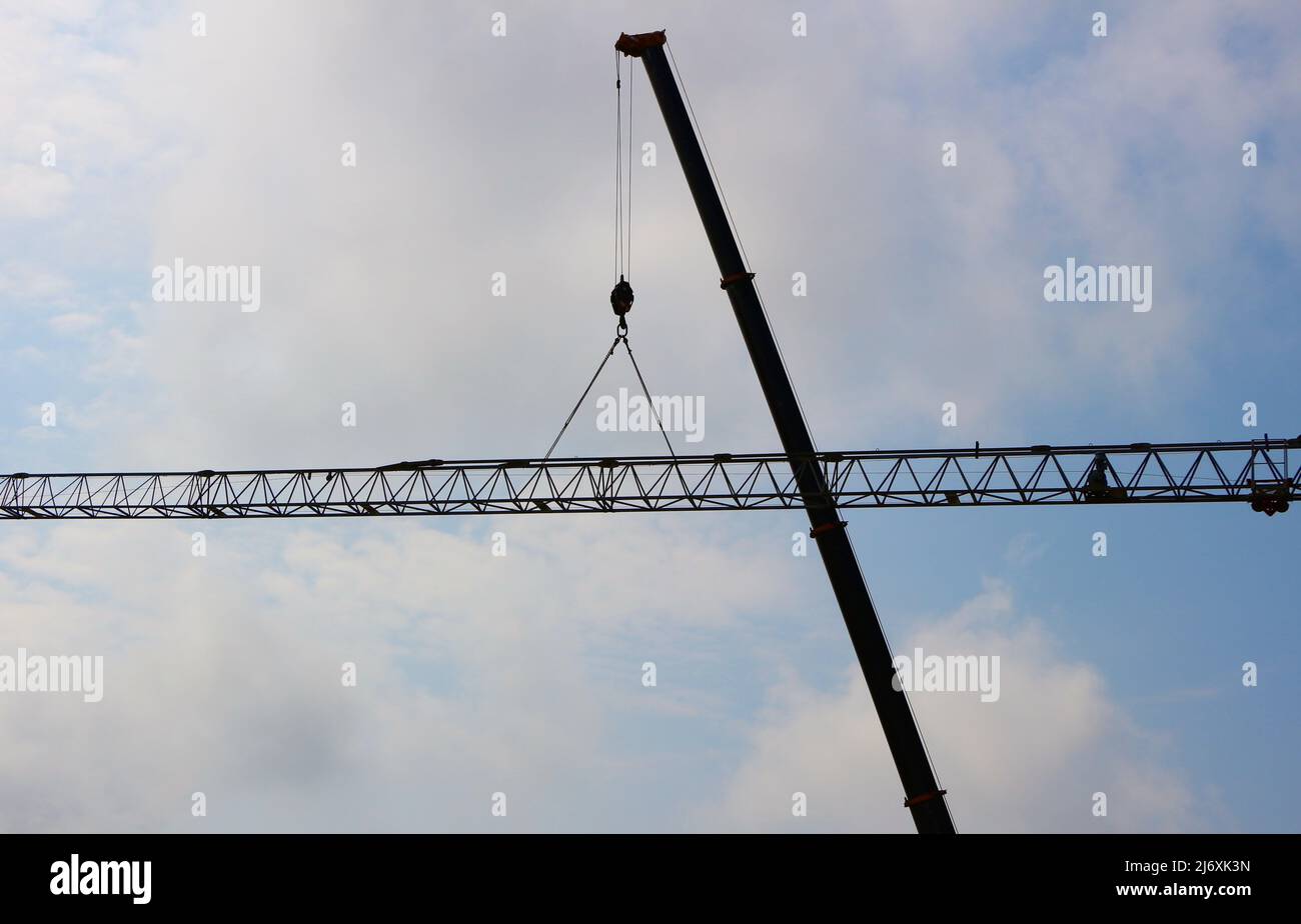 The long working arm of a tower crane during assembly suspended from ...