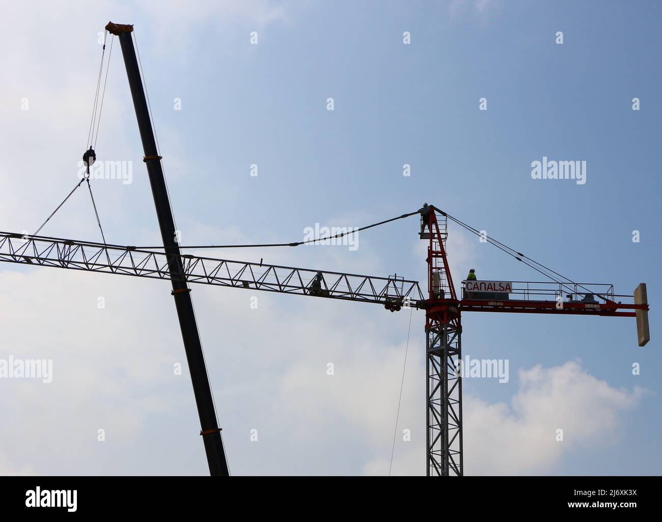 The long working arm of a tower crane during assembly suspended from ...
