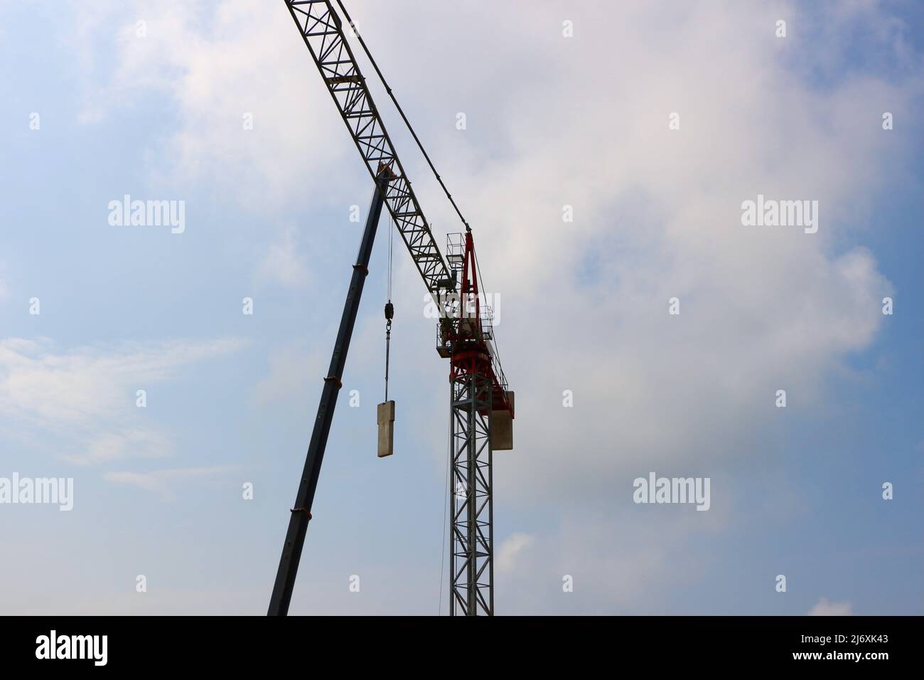 Mobile crane lifting a concrete counterweight into position for a tower ...