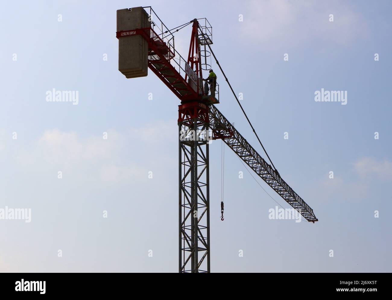 Construction workers on a tower crane working to complete its assembly ...