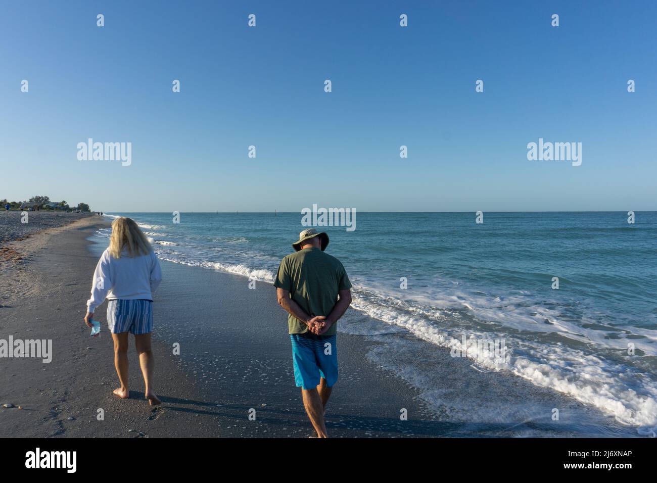 Elderly couple stroll down beach in Florida Stock Photo - Alamy