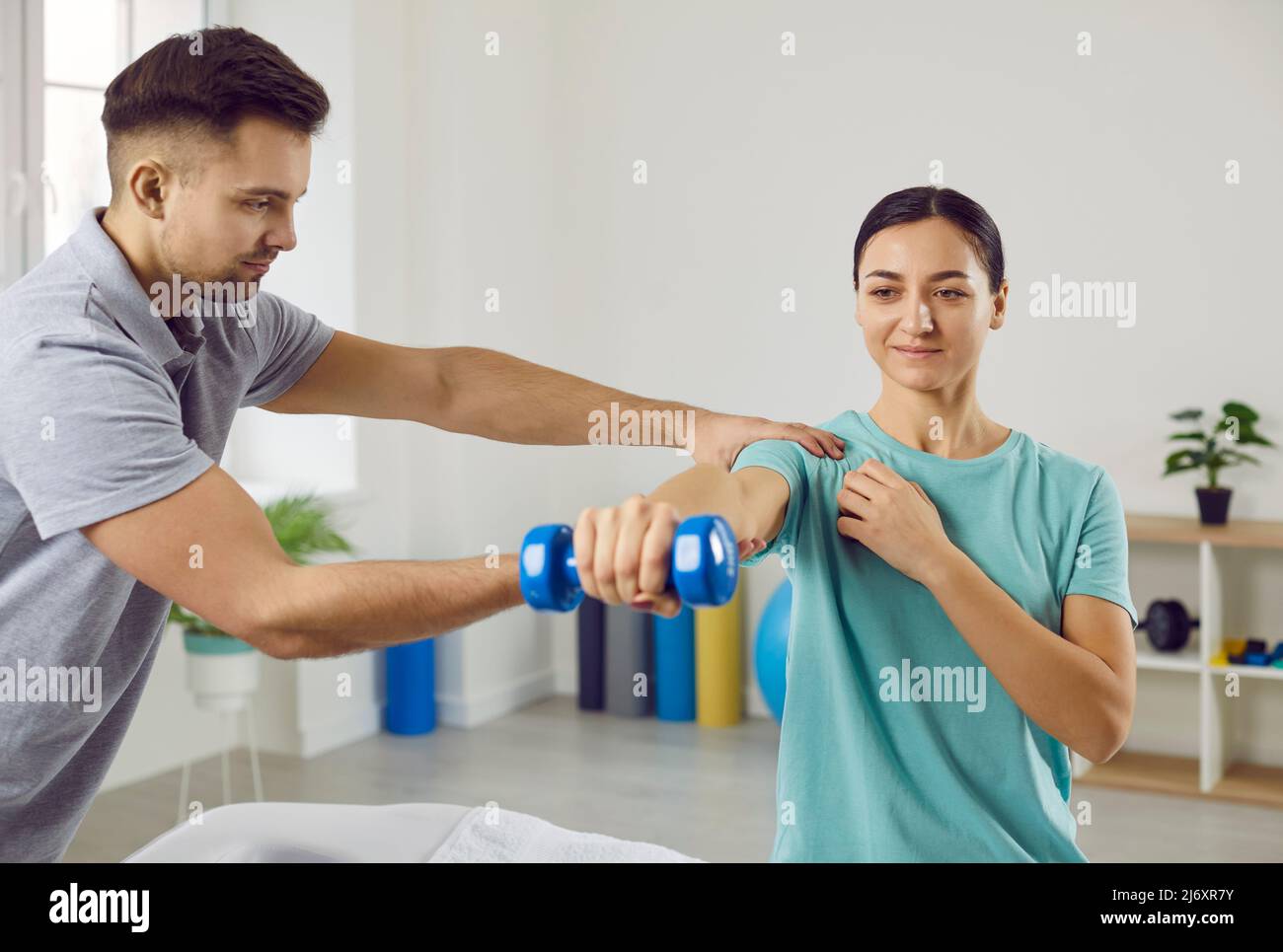 Physiotherapist helping patient to do muscle rehabilitation exercises ...
