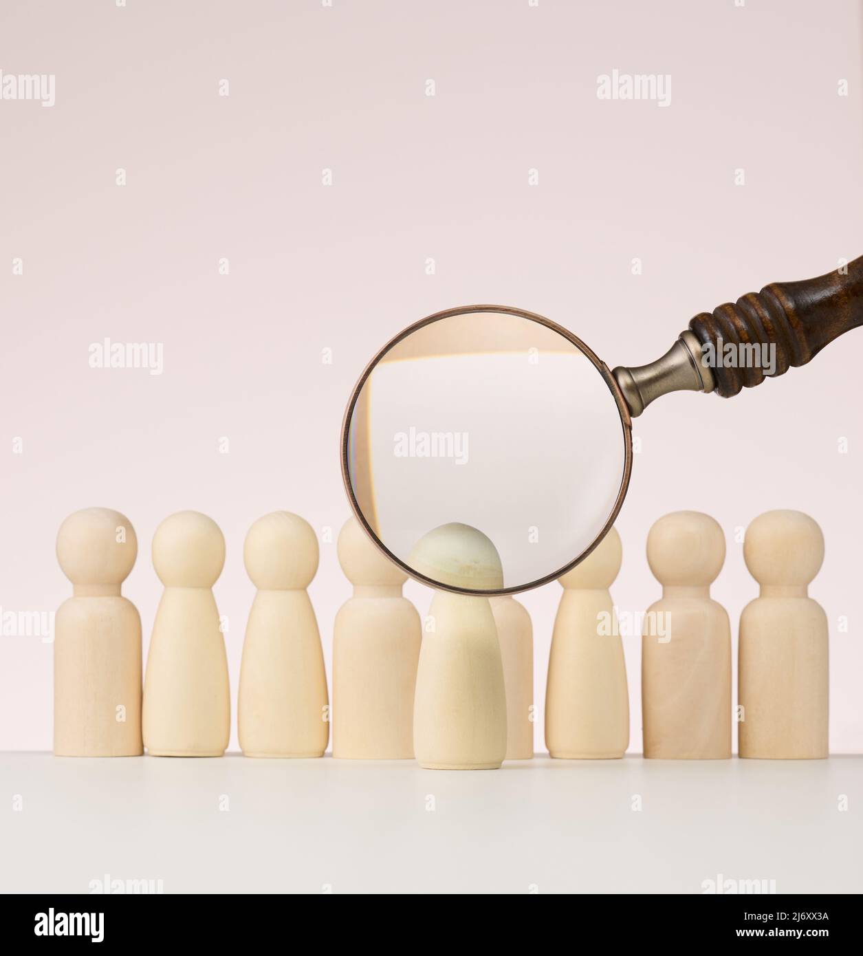 wooden figures of men stand on a beige background and a wooden ...