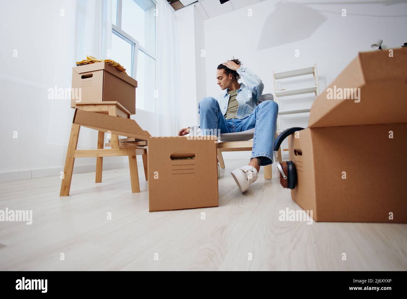 A young man unpacking things from boxes in the room Lifestyle Stock ...