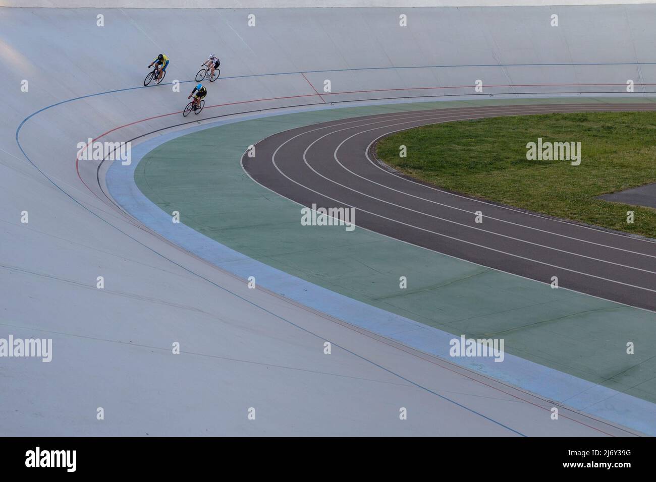 Three cyclists compete on a cycle track in a circle in Kyiv, Ukraine ...