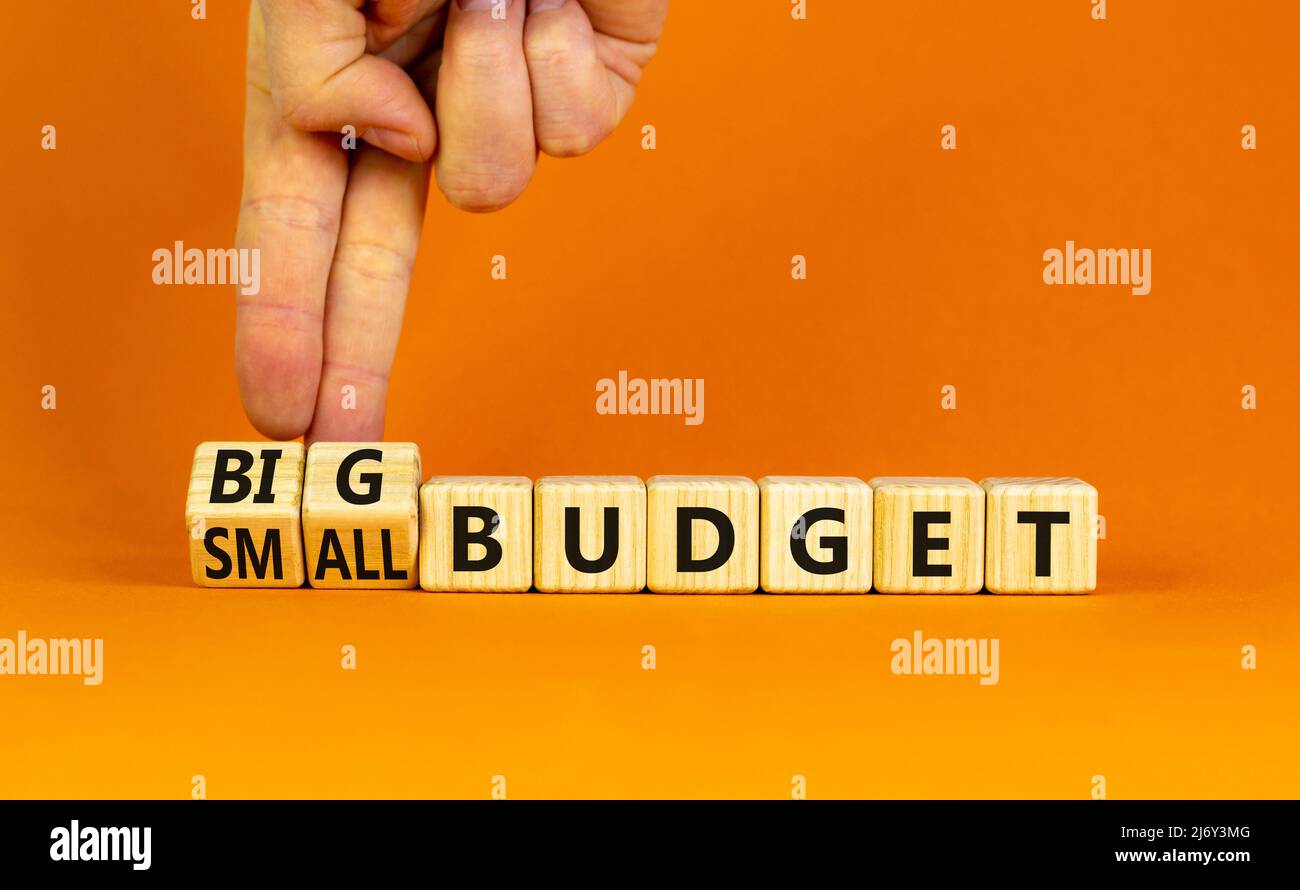 Big or small budget symbol. Businessman turns wooden cubes and changes ...