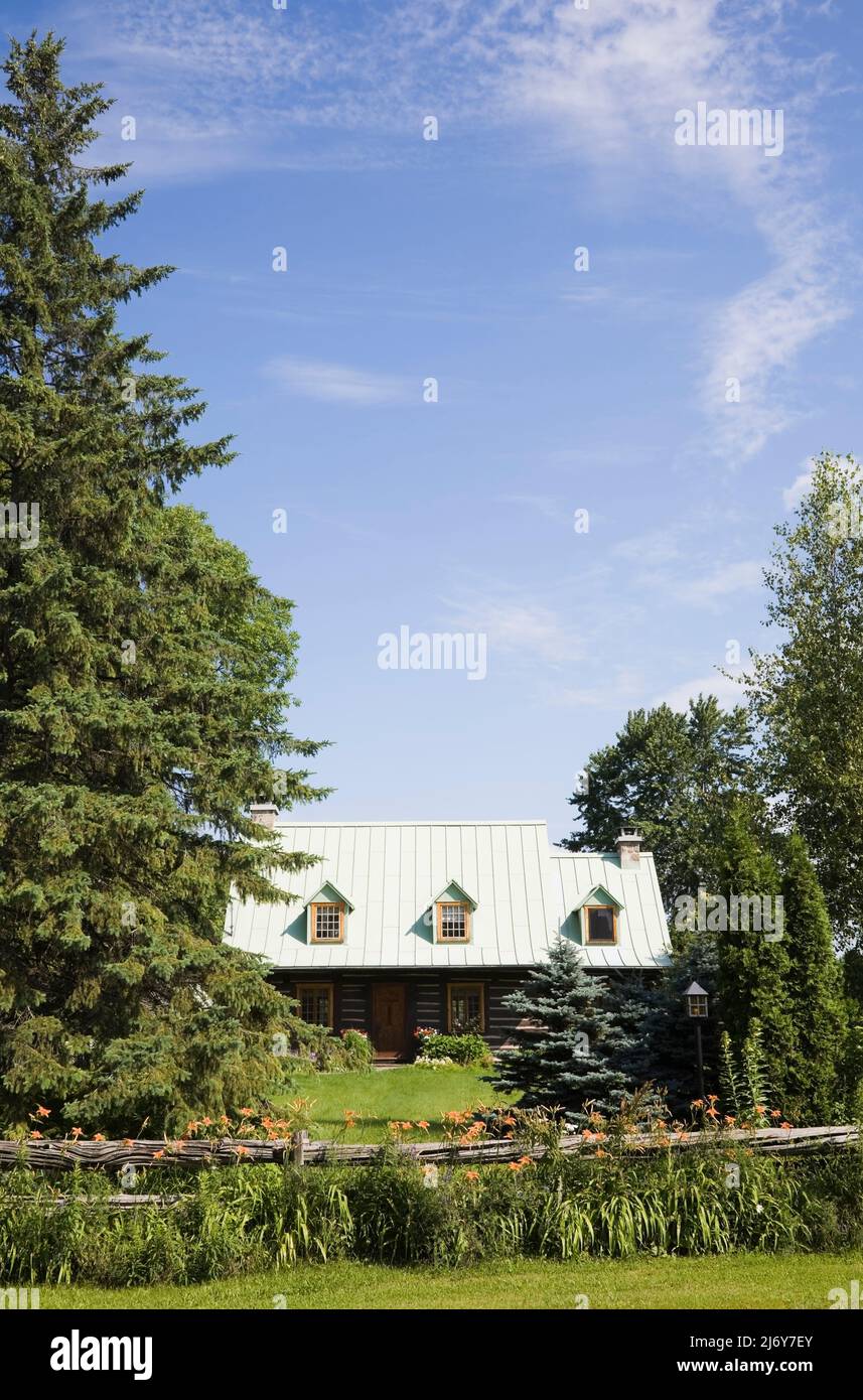 Old 1800s Canadiana style log home with landscaped front yard protected ...
