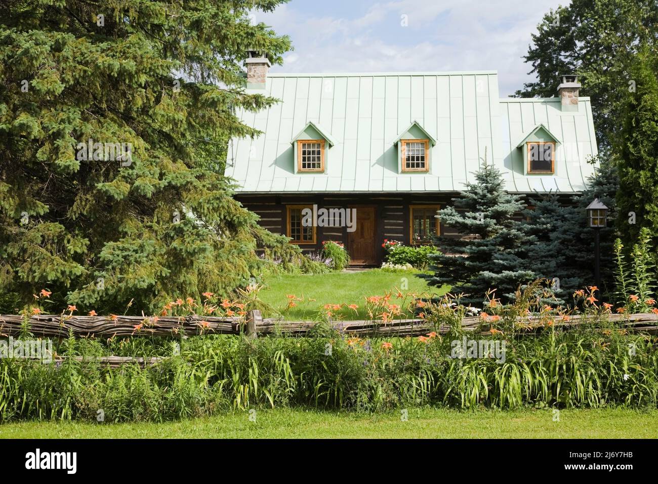 Old 1800s Canadiana style log home with landscaped front yard protected ...