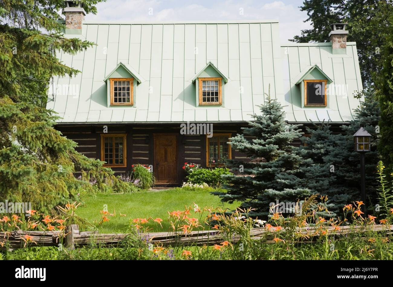 Old 1800s Canadiana style log home with landscaped front yard protected ...