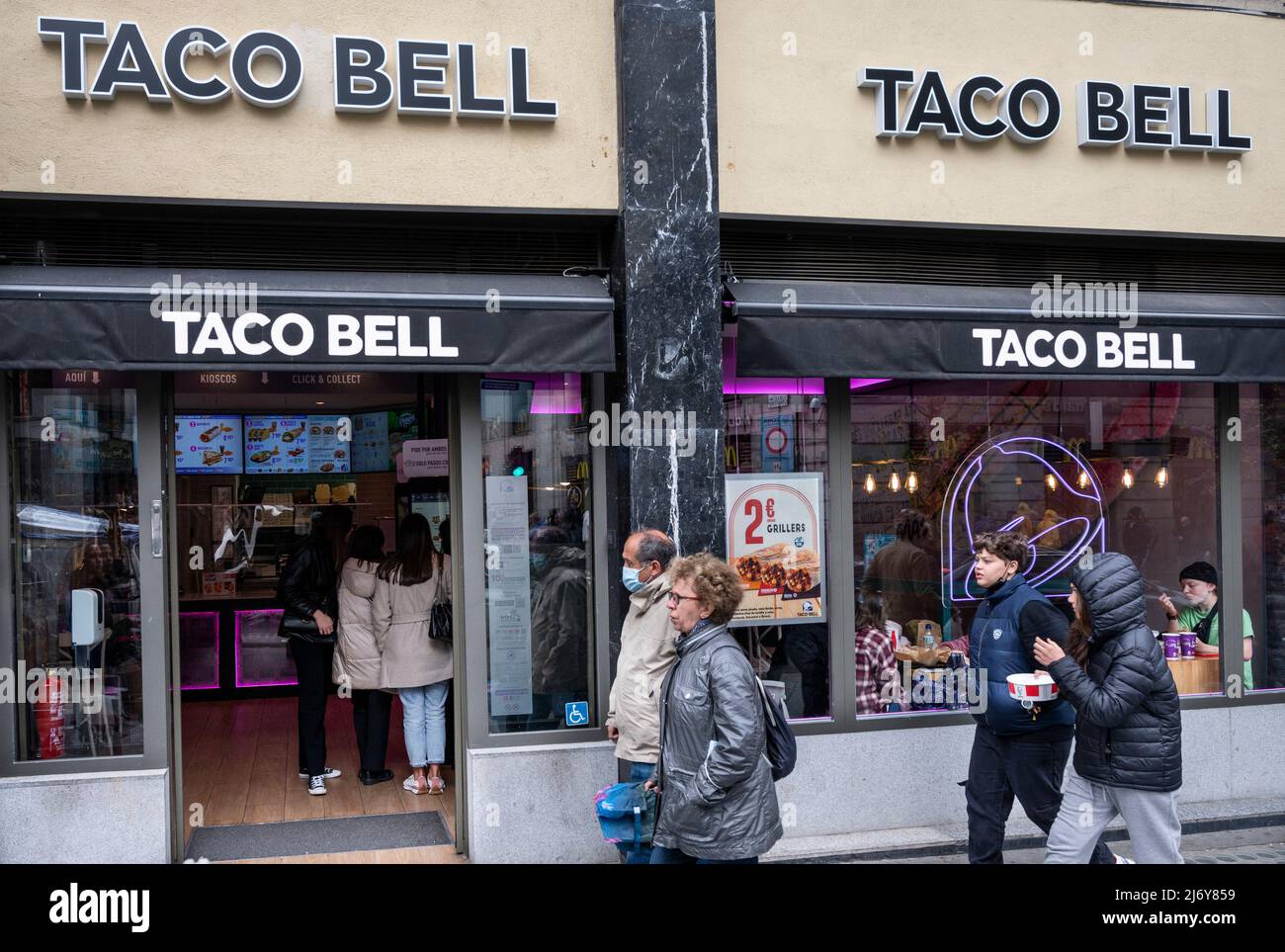 Pedestrians walk past the American chain of fast-food restaurants Taco ...