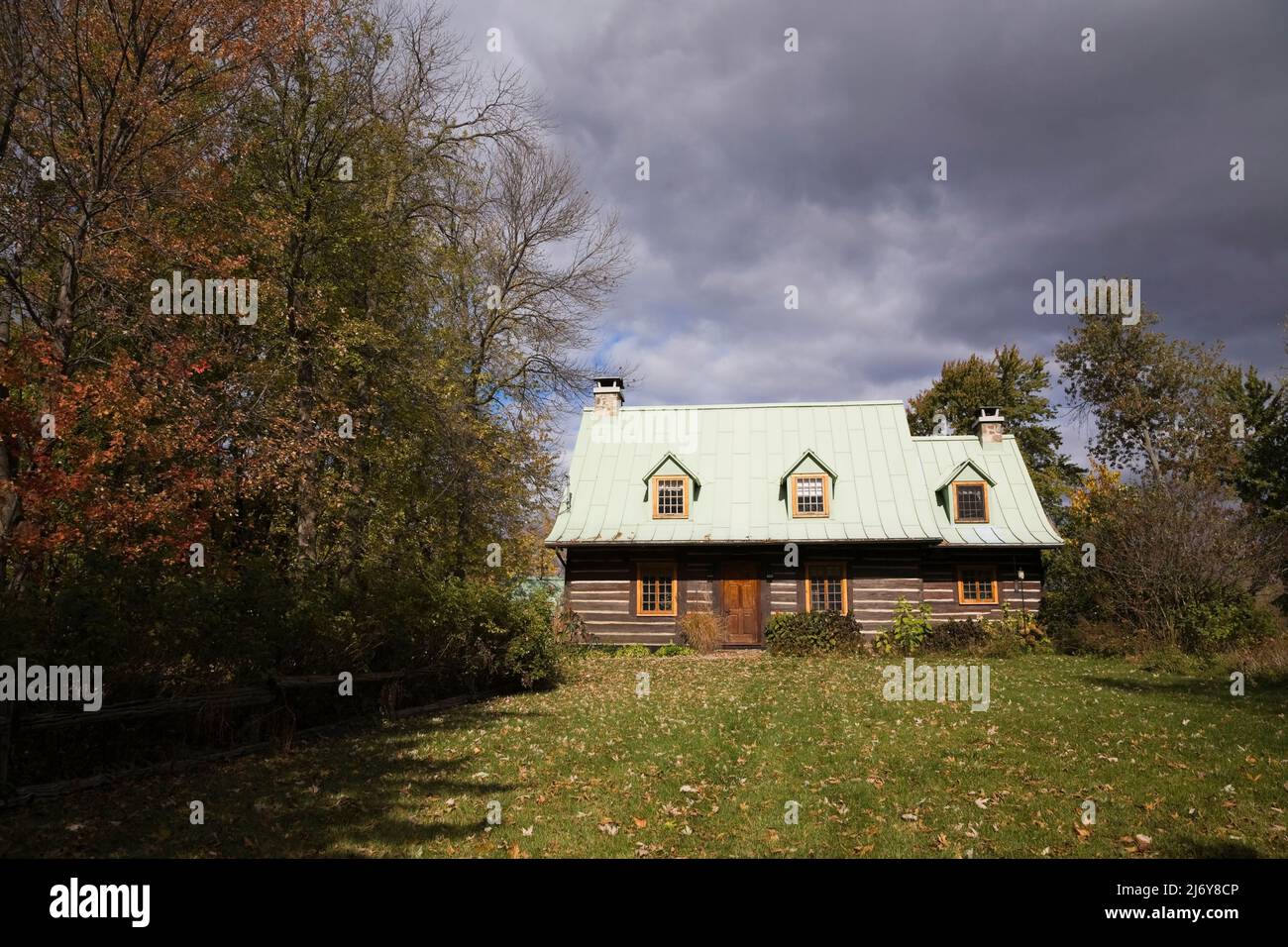 Old 1800s Canadiana style log home with landscaped front yard in autumn ...
