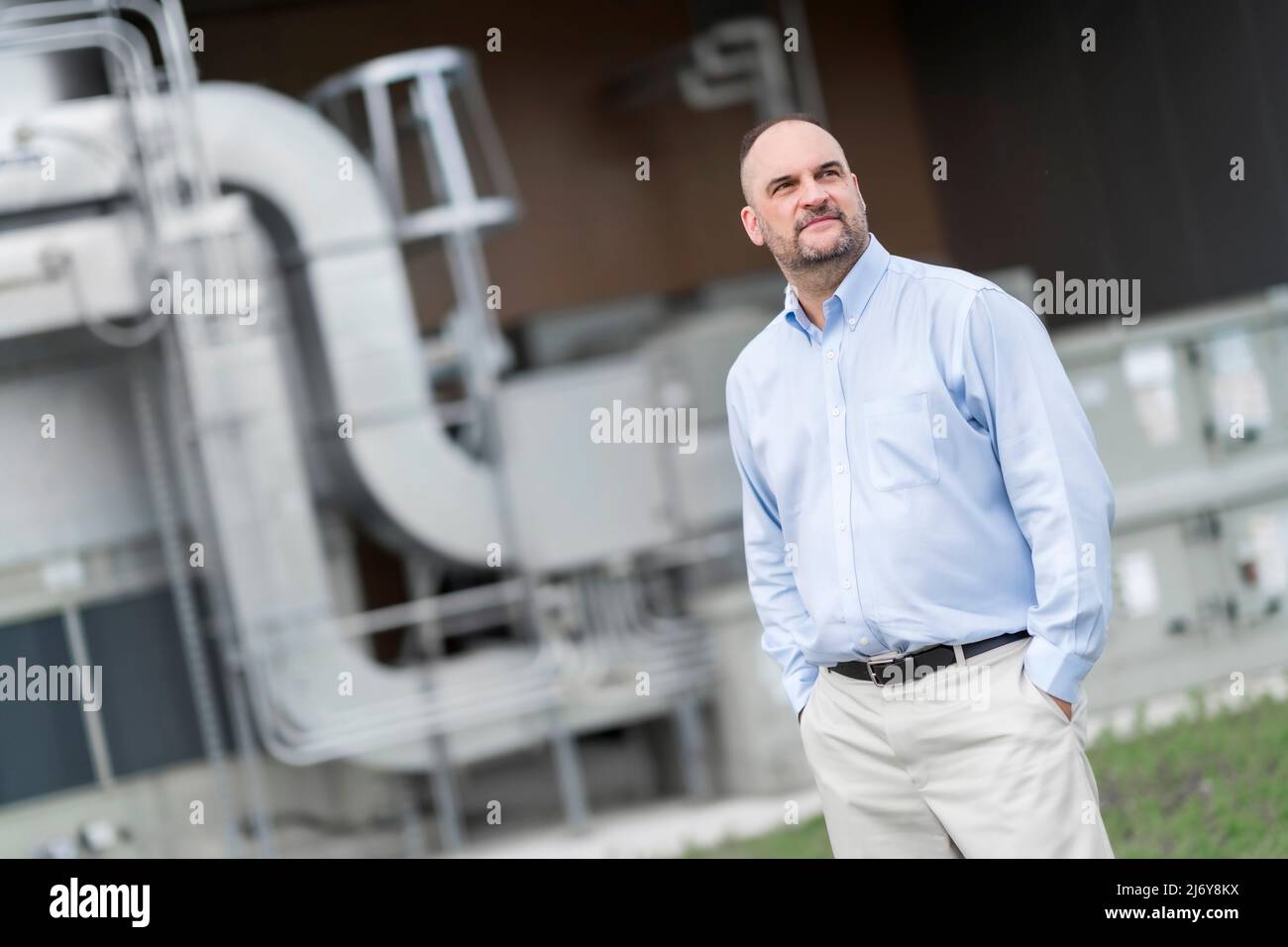 Visionary man standing confidently in front of plant Stock Photo - Alamy
