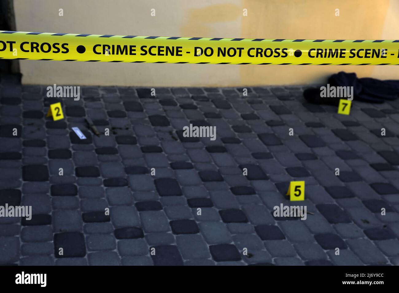 Crime scene tape for covering the area cordon. Yellow tape with blurred forensic law enforcement ...