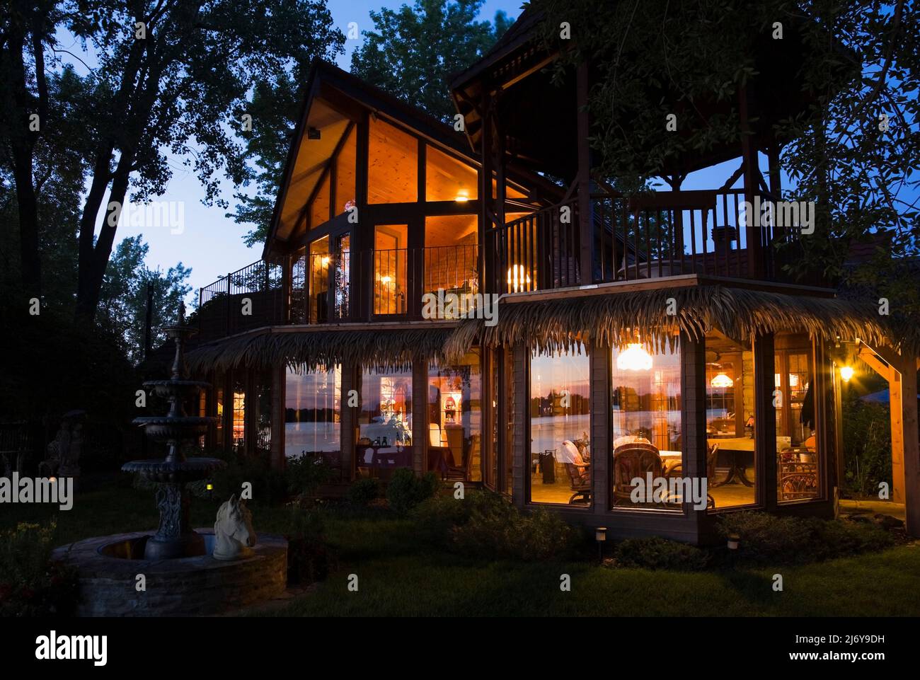 Rear view of modern tropical timber frame style home at dusk Stock ...