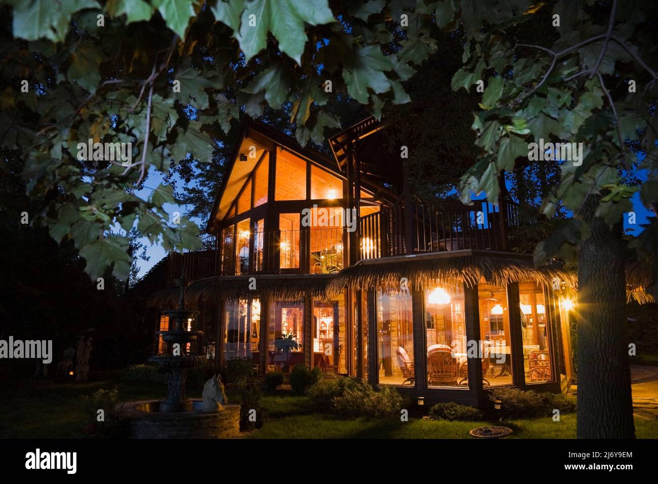 Rear view of modern tropical timber frame style home at dusk Stock ...