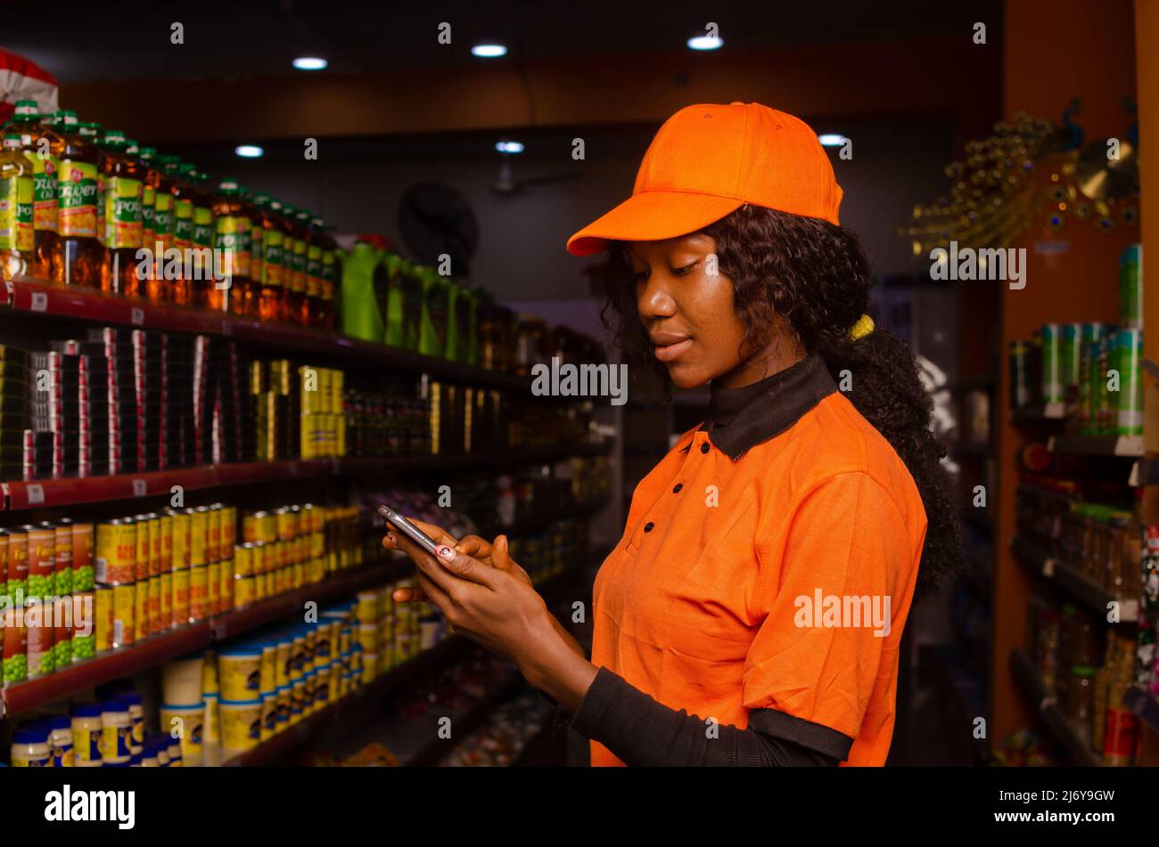 Woman using mobile phone while shopping in supermarket Stock Photo - Alamy